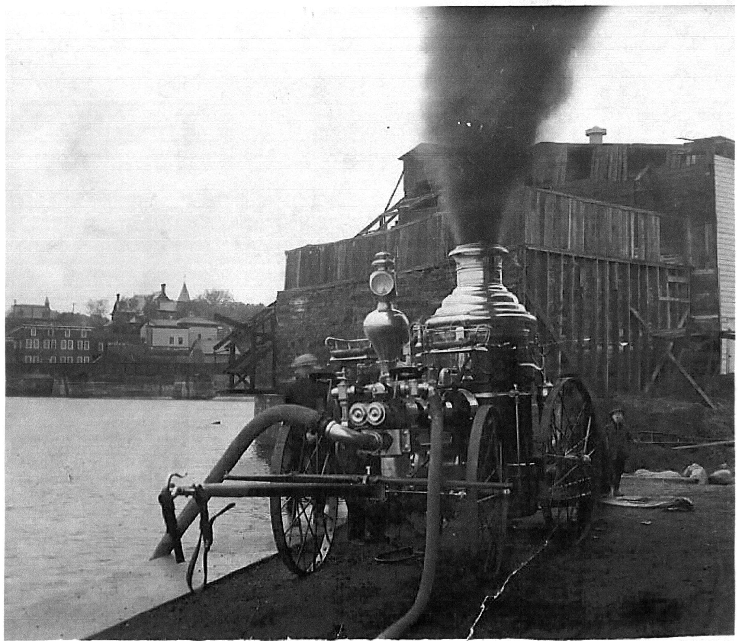 Firemen fill a steam pumper from the Black River in Carthage