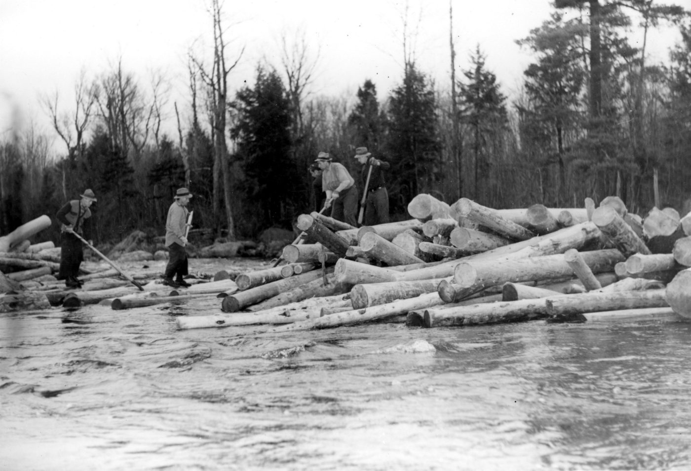 Five loggers breaking log jam in Town of Webb