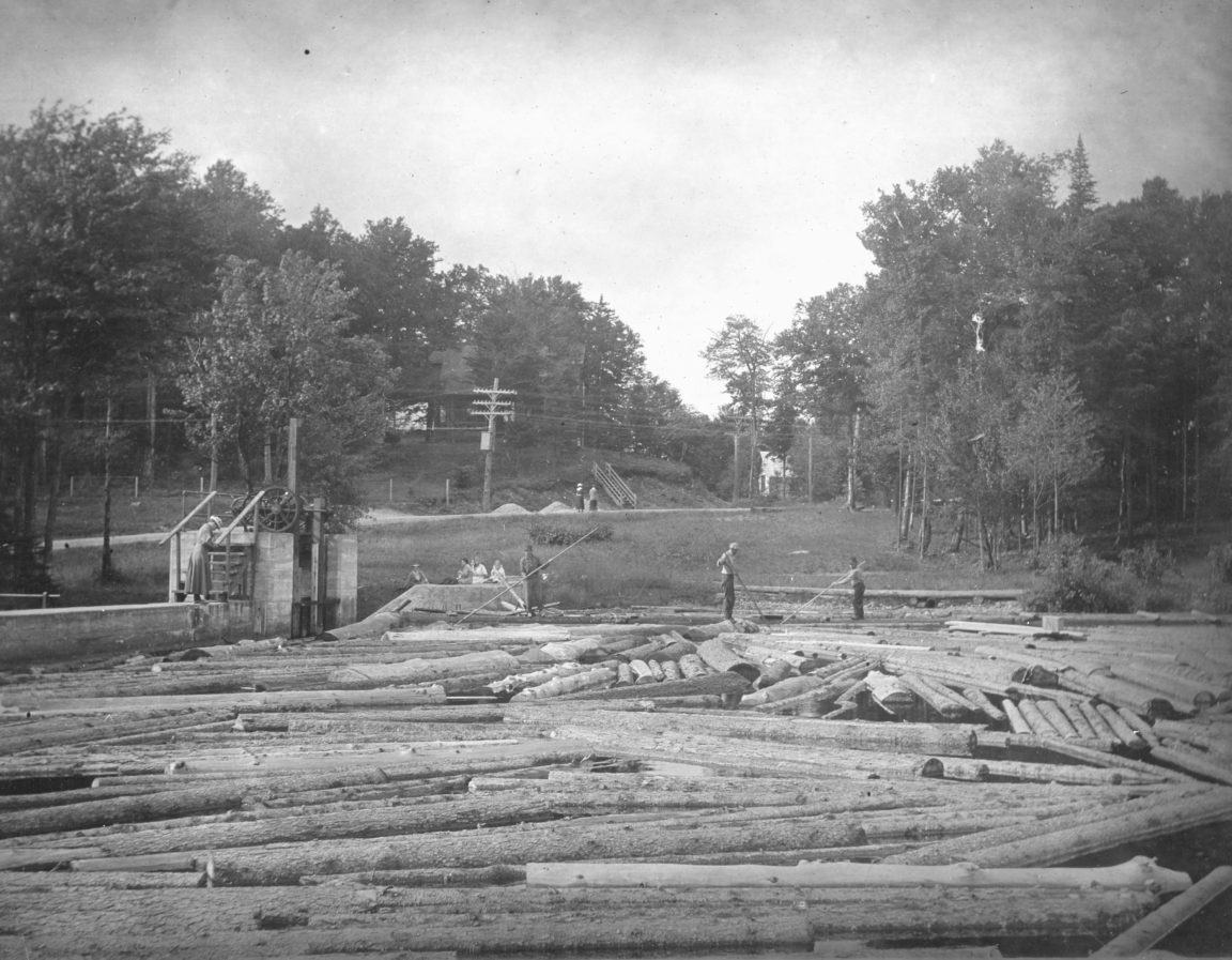 Loggers guide logs into the flume at the Old Forge Dam