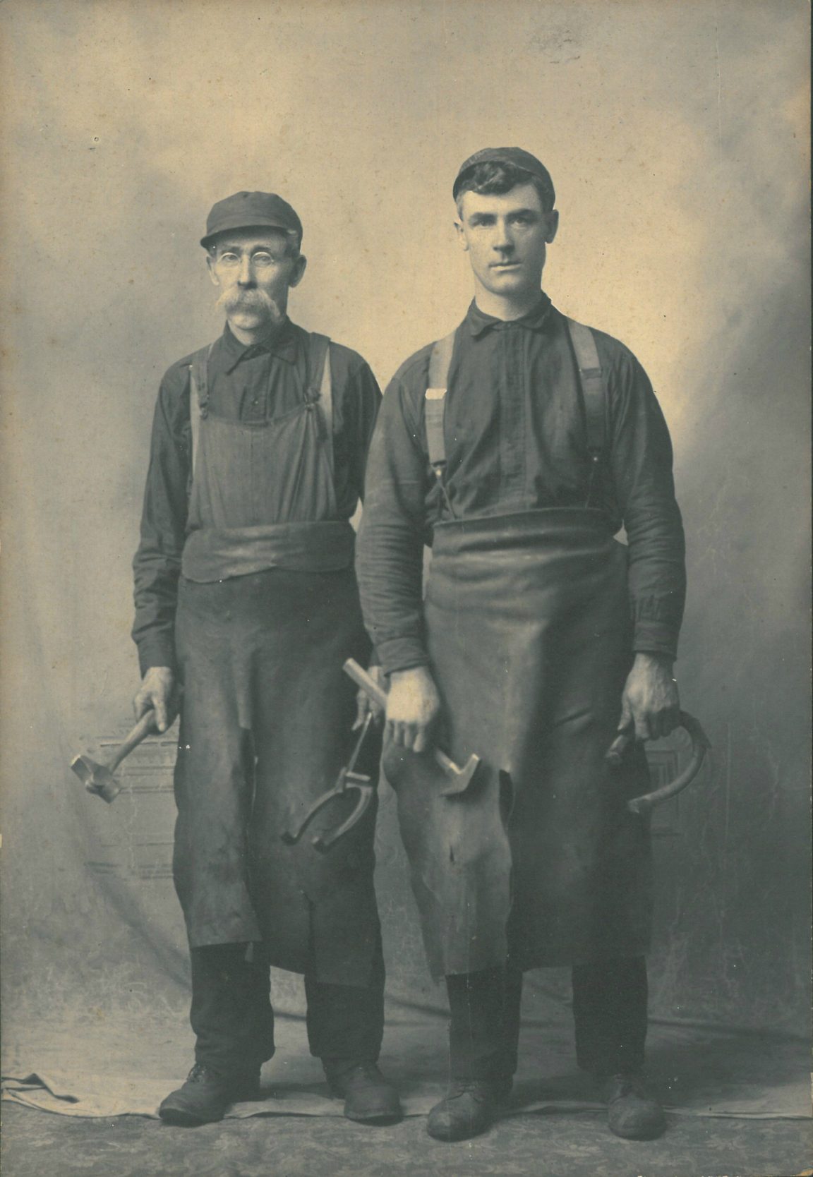 Two blacksmiths photographed with their tools in Canton