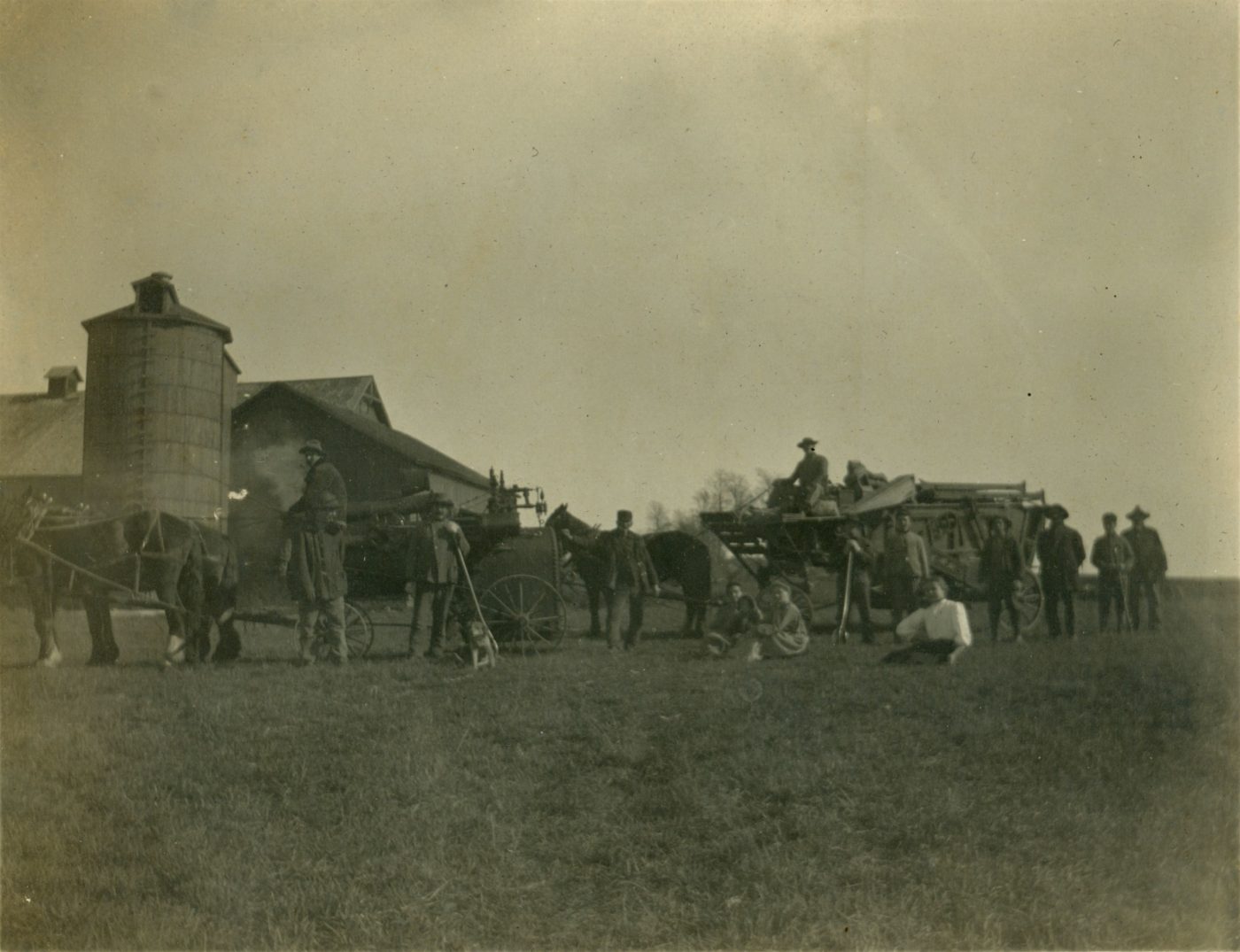 Work crew posing with threshing equipment in Hermon