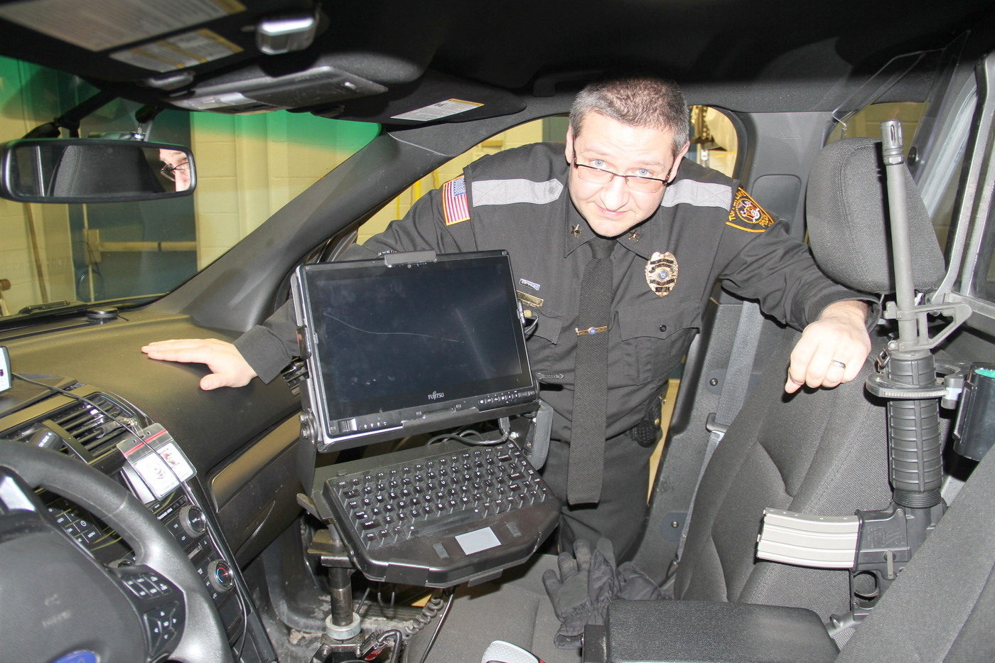 Eric Proulx shows off the inside of a TLPD cruiser in Tupper Lake