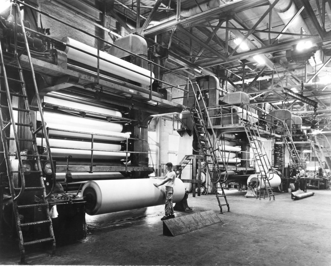 Worker at a super calendar machine at the St. Regis Paper Company mill ...
