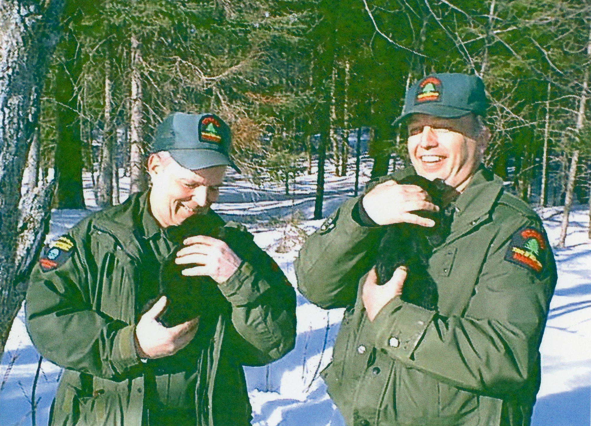 Forest rangers hold black bear cubs in Colton