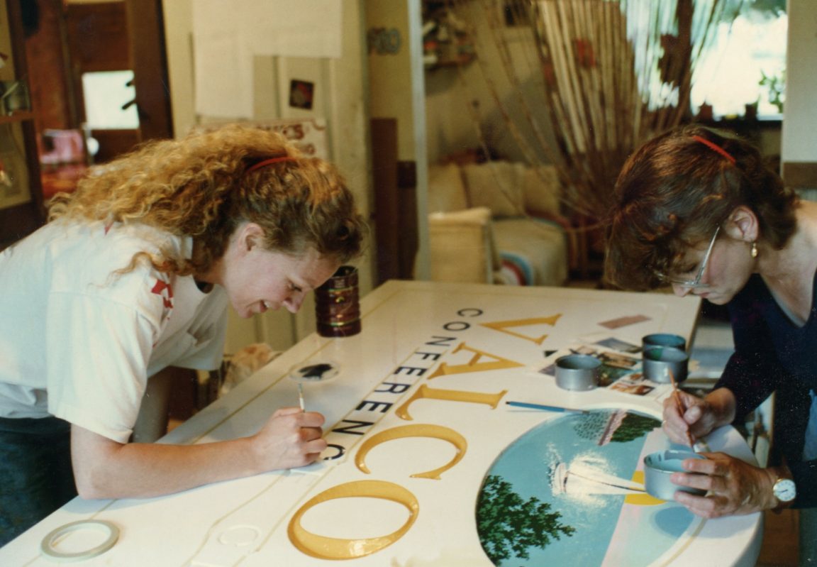 KC Reiter painting a handmade sign in her home in Morrisonville