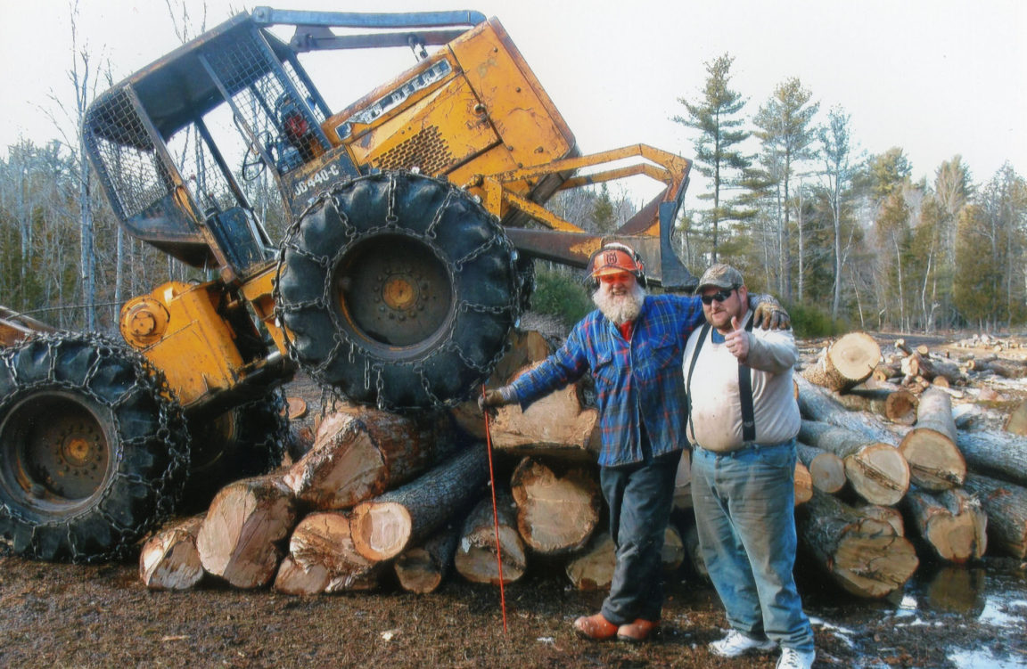 Two lumberjacks posing next to a pile of logs in Elizabethtown