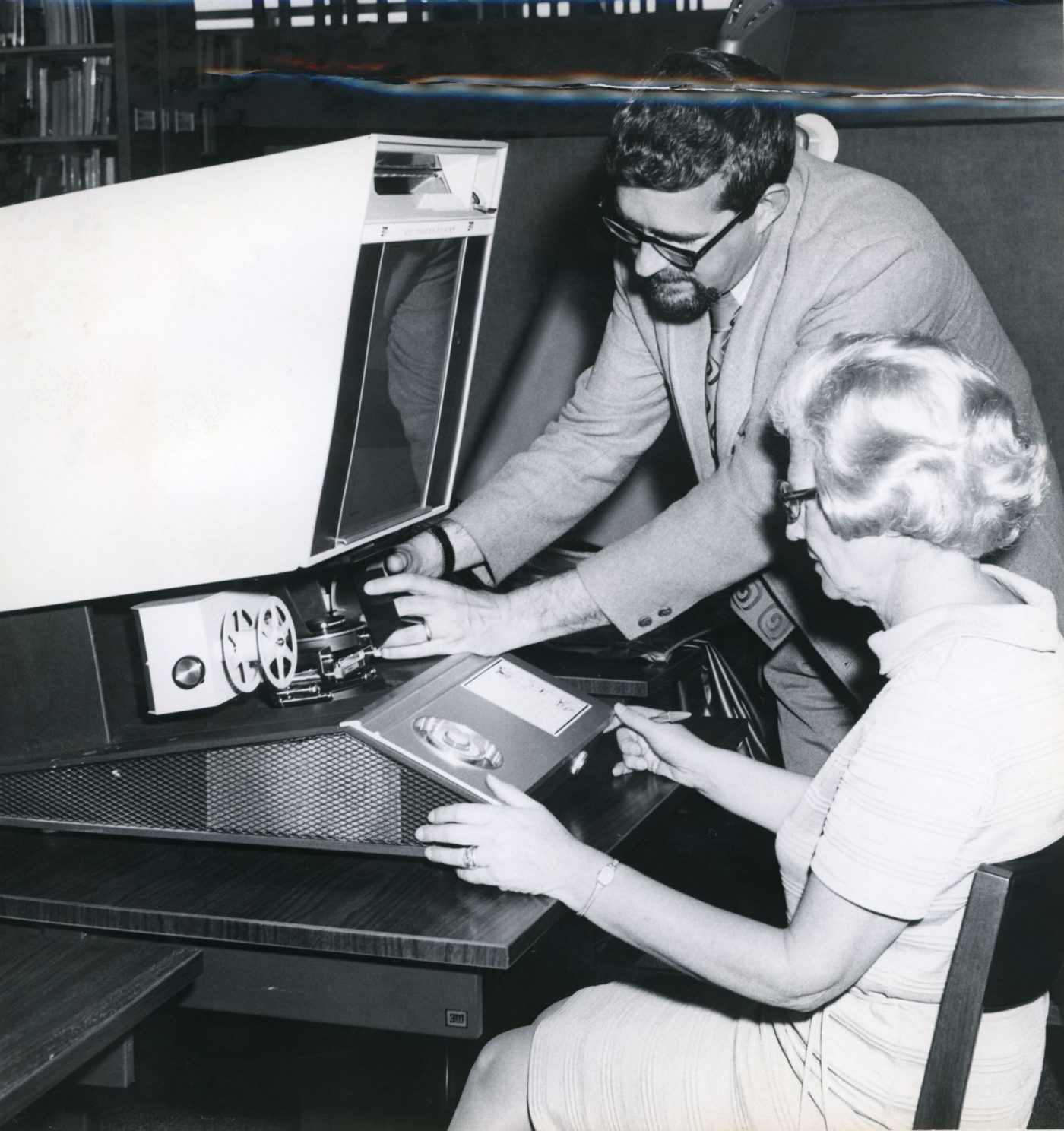 Reference assistants using a microfilm reader at Crandall Public ...